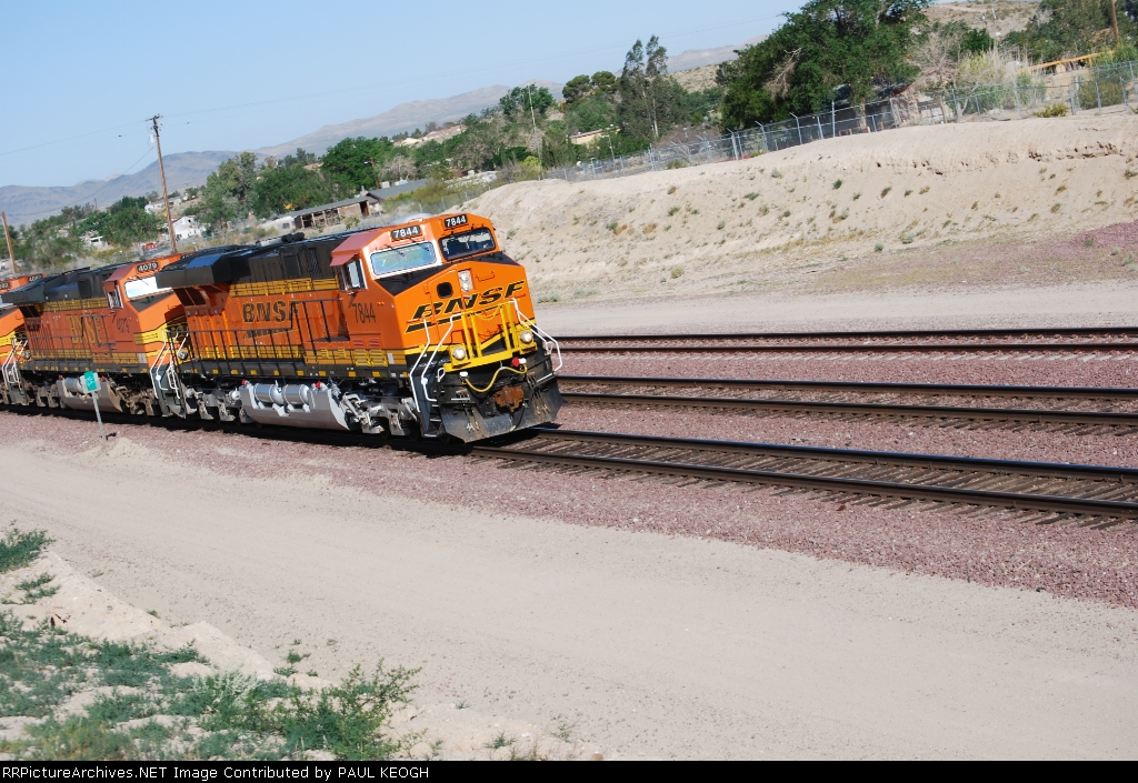 BNSF 7844 rolls east with a Z train as she slows to enter the yard at Barstow for a crew swap ...
